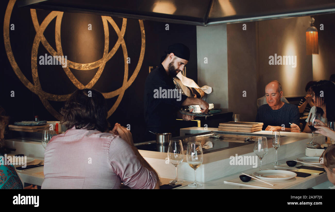 Chef cooking food in front of guests at restaurant Do Fusion in a ...