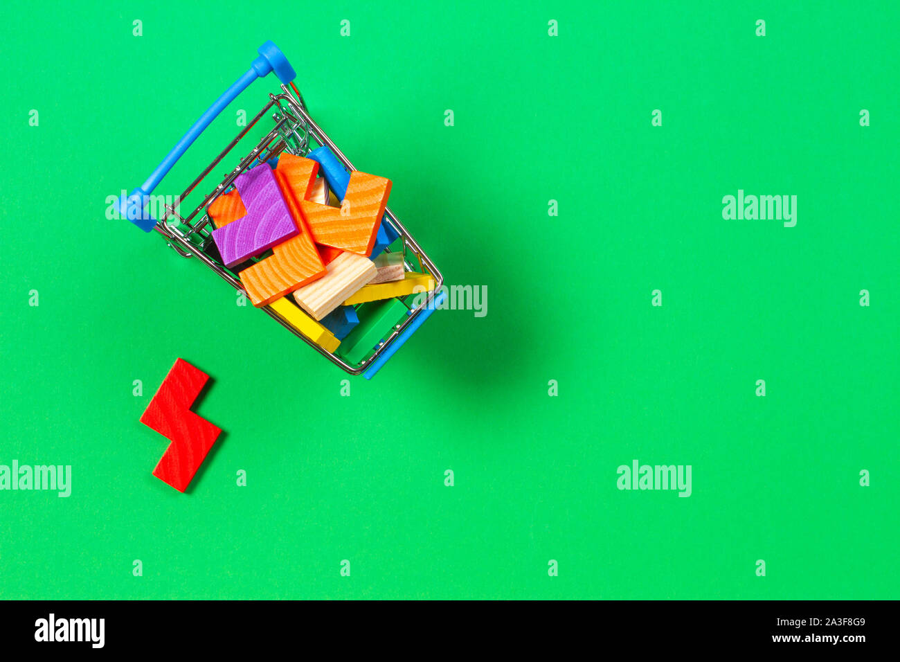 Mini shopping trolley cart full of colorful toy puzzle bricks on green ...
