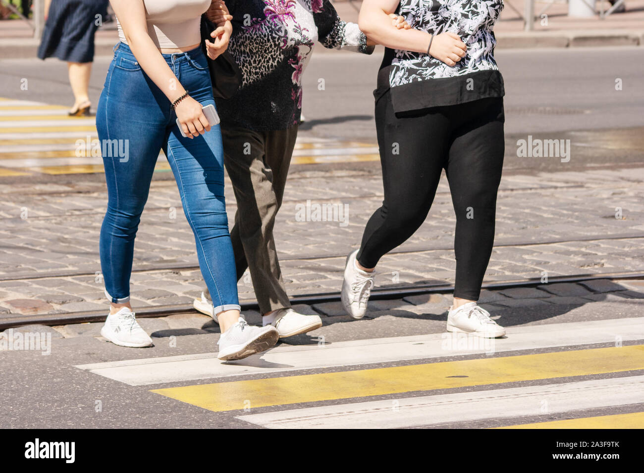 legs of young pedestrians walking on the crosswalk in the city on ...