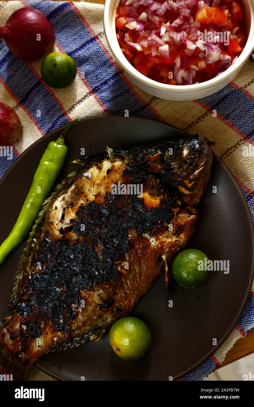 Photo of freshly grilled tilapia fish on plate with garnishing Stock ...