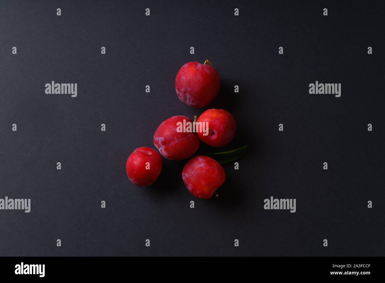 Red sweet cherry plums on dark background. Overhead view Stock Photo ...