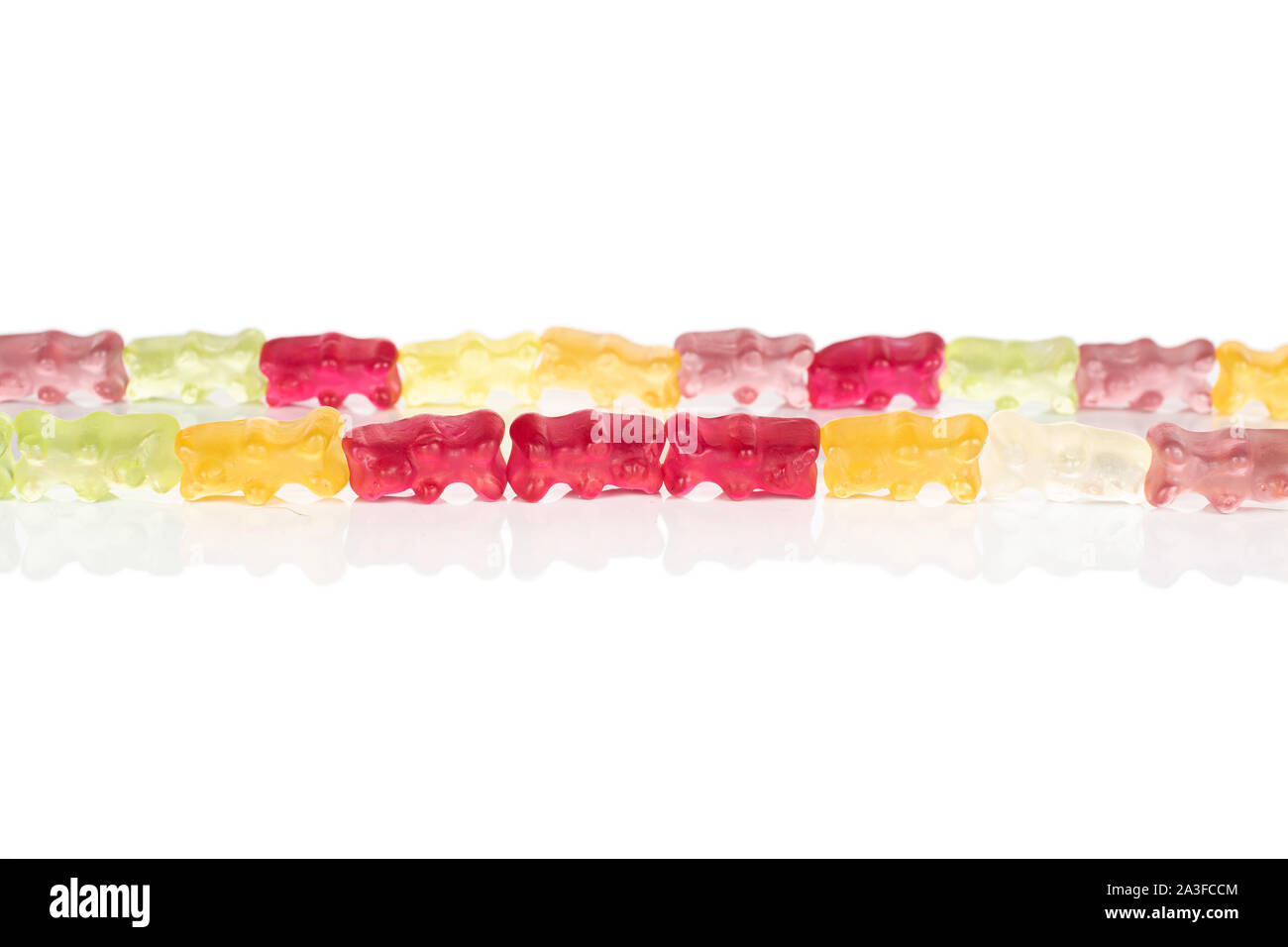 Lot of whole arranged gummy bear in row isolated on white background ...