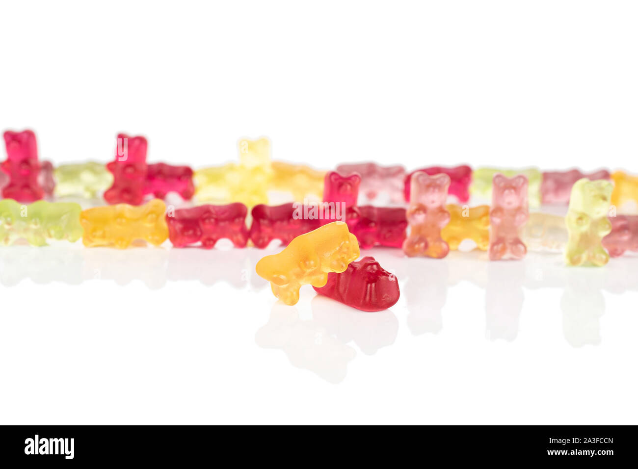 Lot of whole arranged gummy bear in row isolated on white background ...