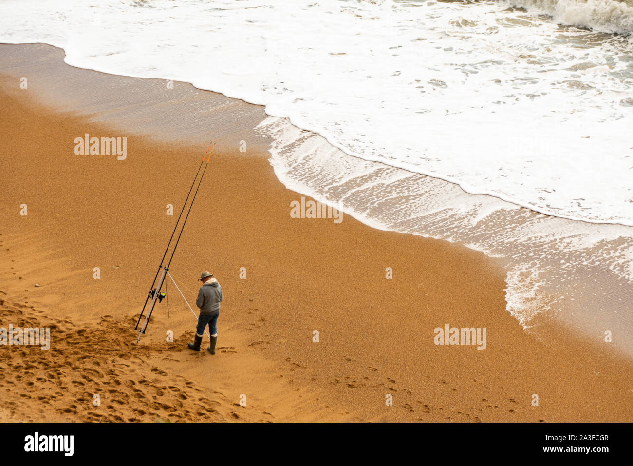 A man sea fishing on the beach Stock Photo - Alamy