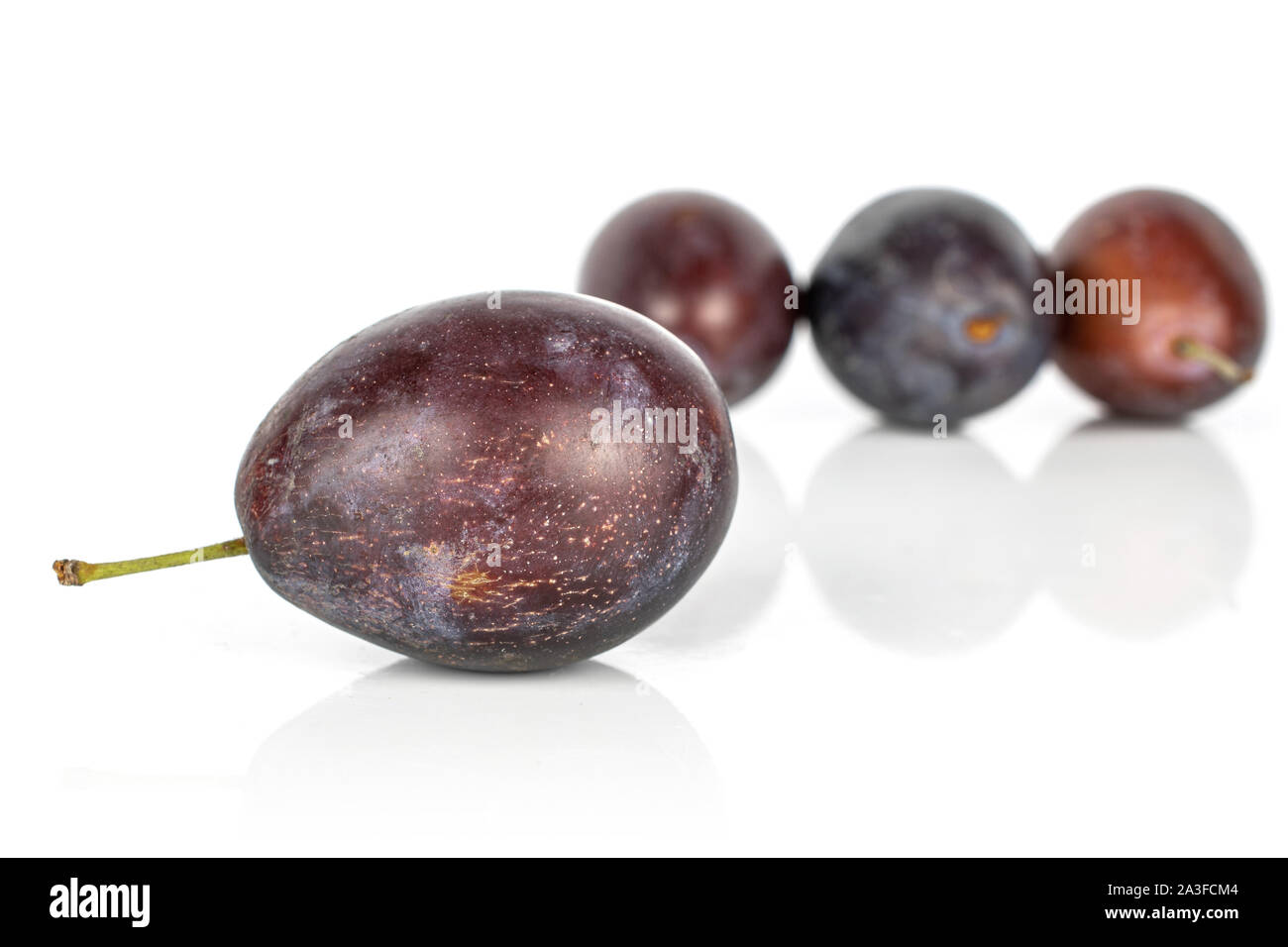 Group of four whole sweet purple plum isolated on white background ...