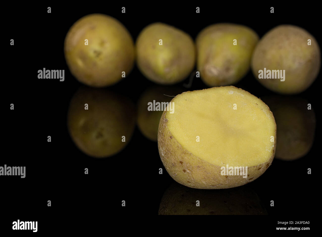 Group of four whole one half of raw brown potato isolated on black ...