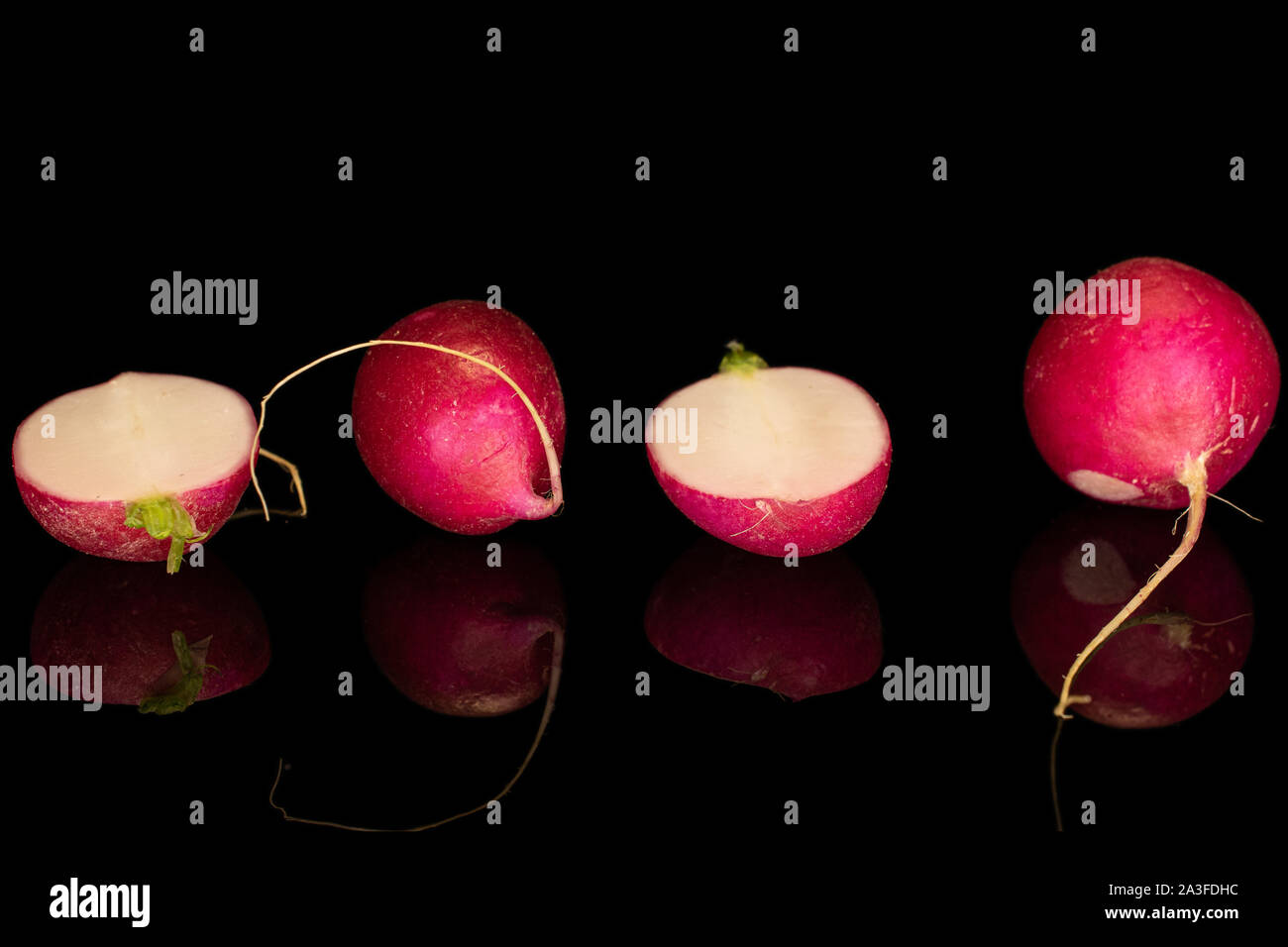 Group of two whole two halves of fresh red radish isolated on black ...