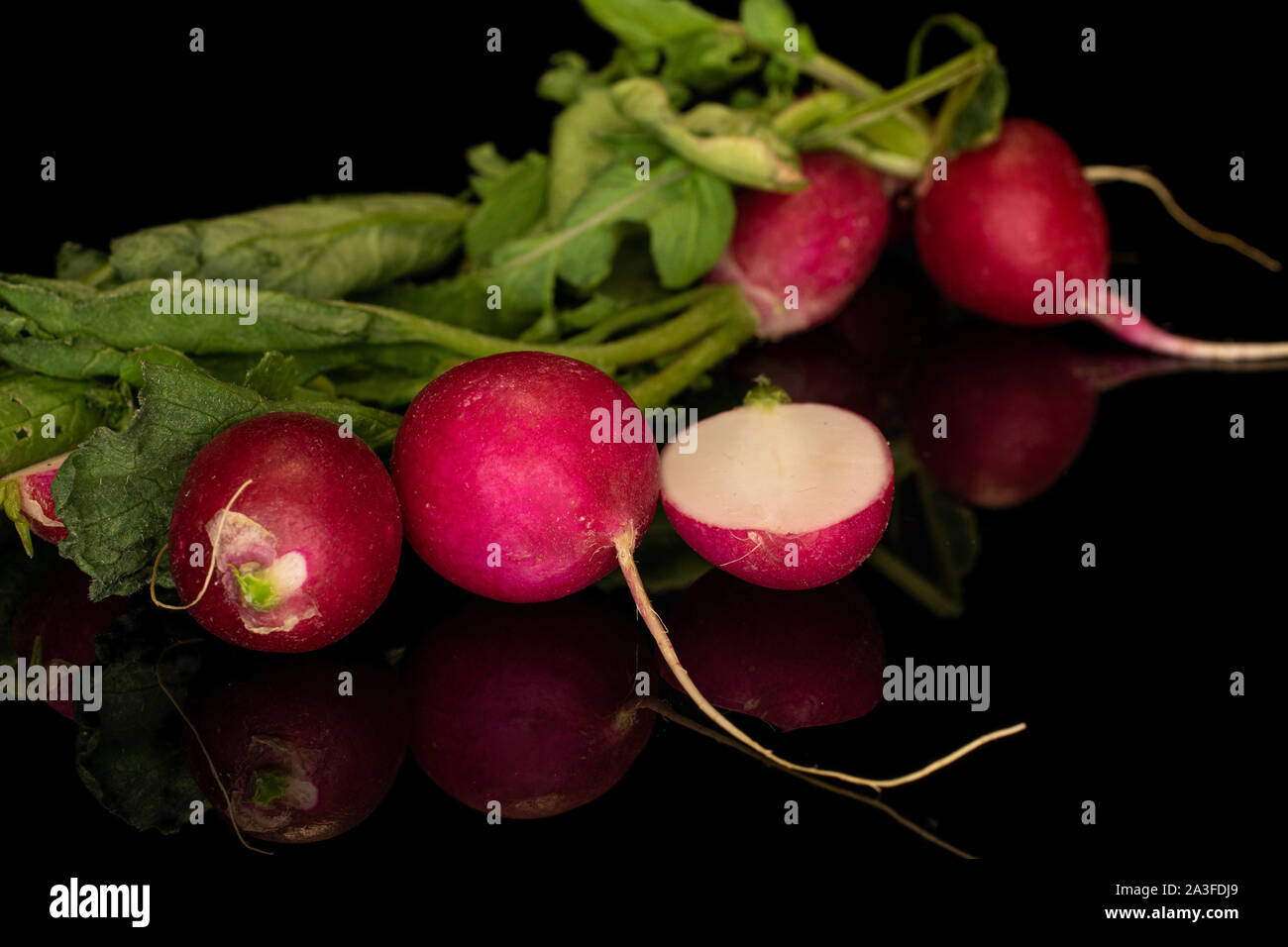 Group of four whole one half of fresh red radish isolated on black ...