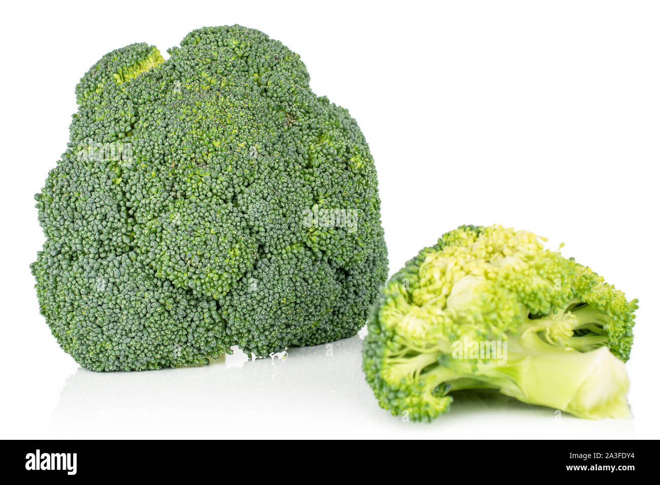 Group of two whole light fresh green broccoli front focus isolated on ...