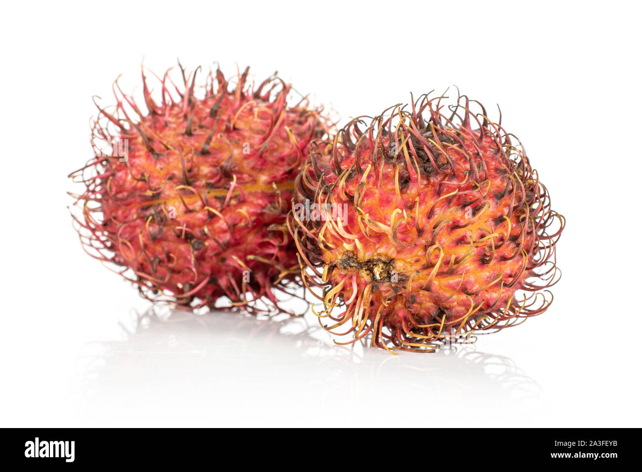 Group of two whole unpeeled fresh red rambutan isolated on white ...