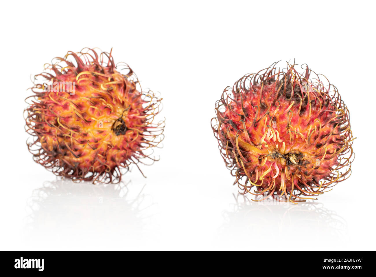 Group of two whole unpeeled fresh red rambutan isolated on white ...