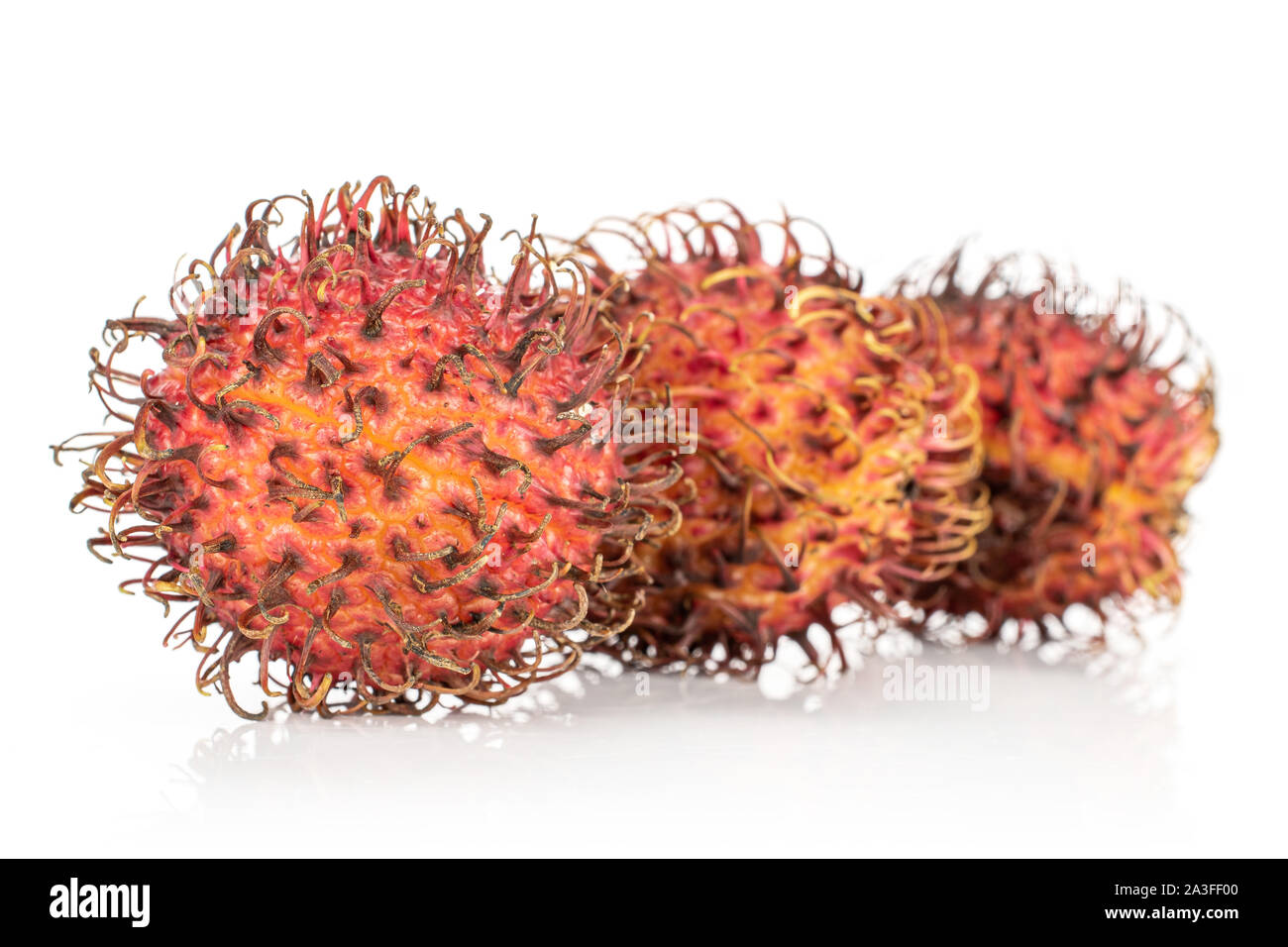 Group of three whole unpeeled fresh red rambutan isolated on white ...