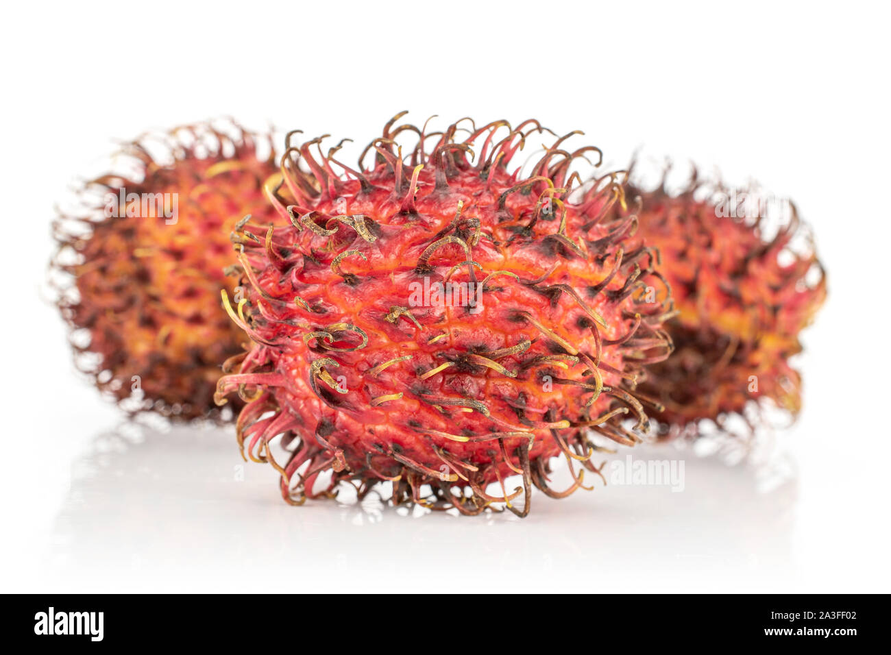 Group of three whole unpeeled fresh red rambutan isolated on white ...