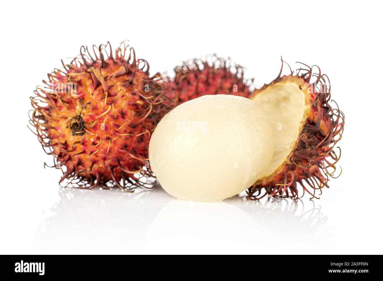 Group of three whole one half of fresh red rambutan one peeled isolated ...