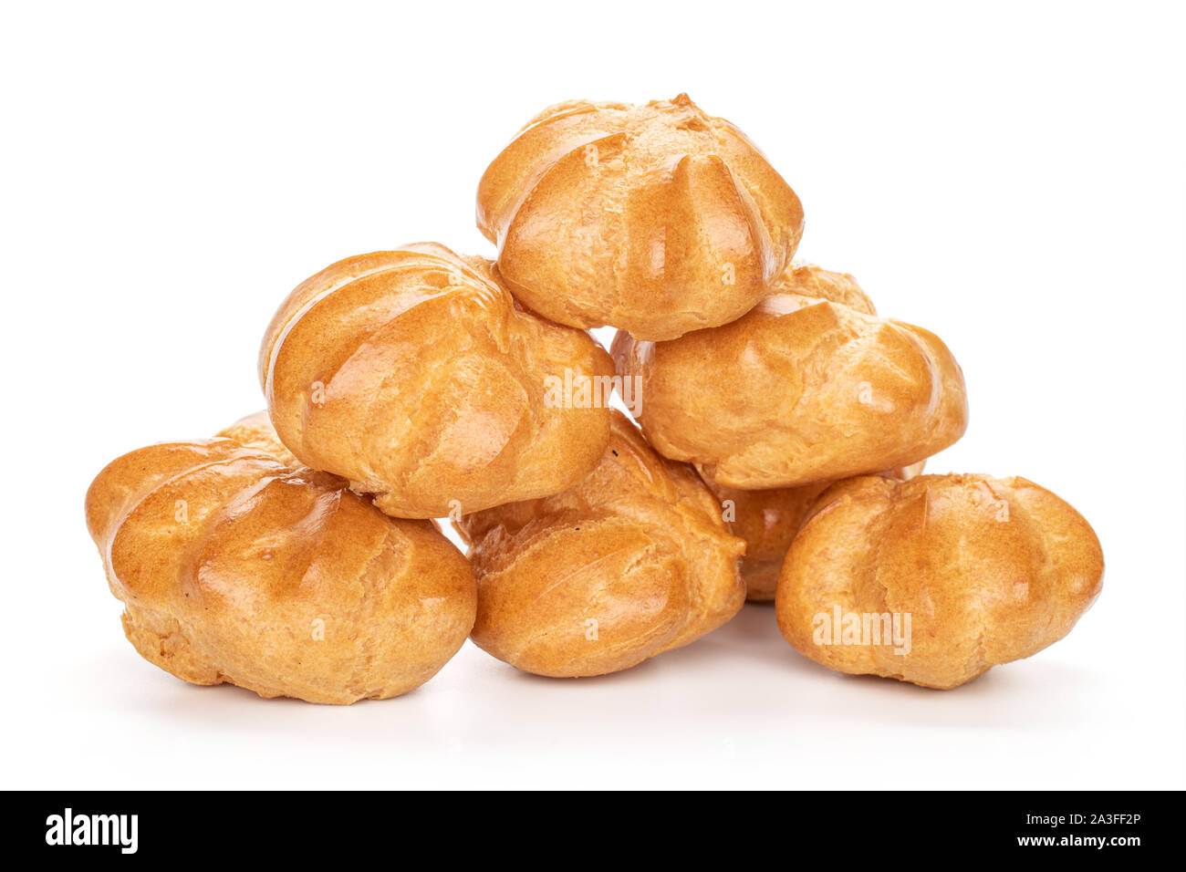 Group of six whole baked golden profiterole pyramid isolated on white ...