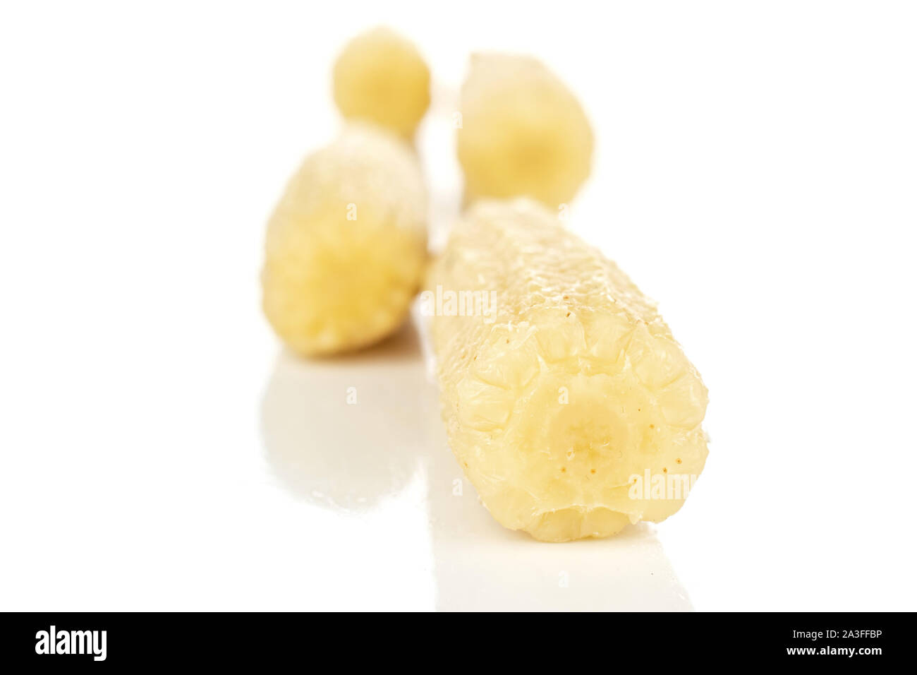 Group of four whole baby yellow corn in row isolated on white ...