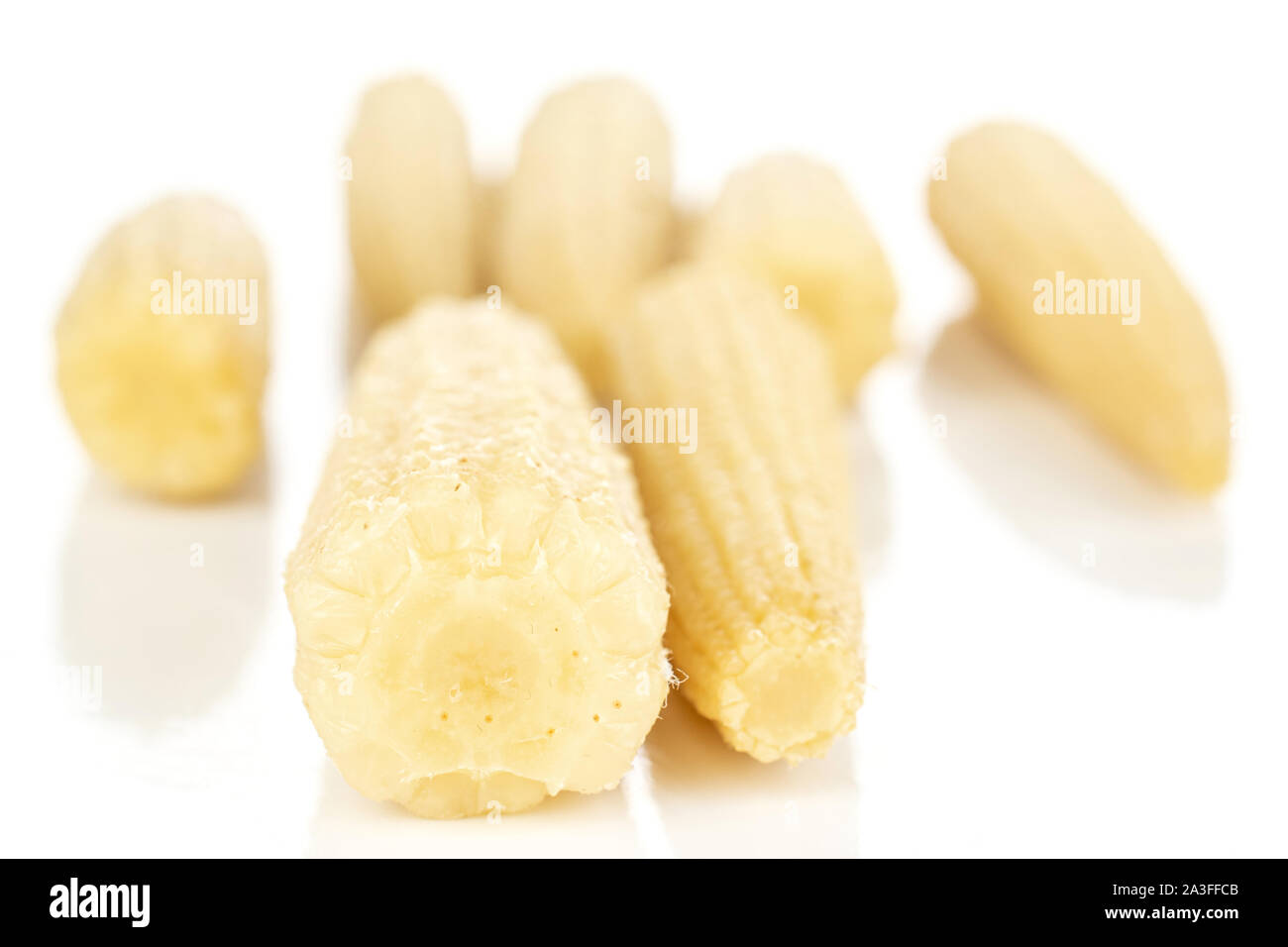 Group of seven whole baby yellow corn isolated on white background ...