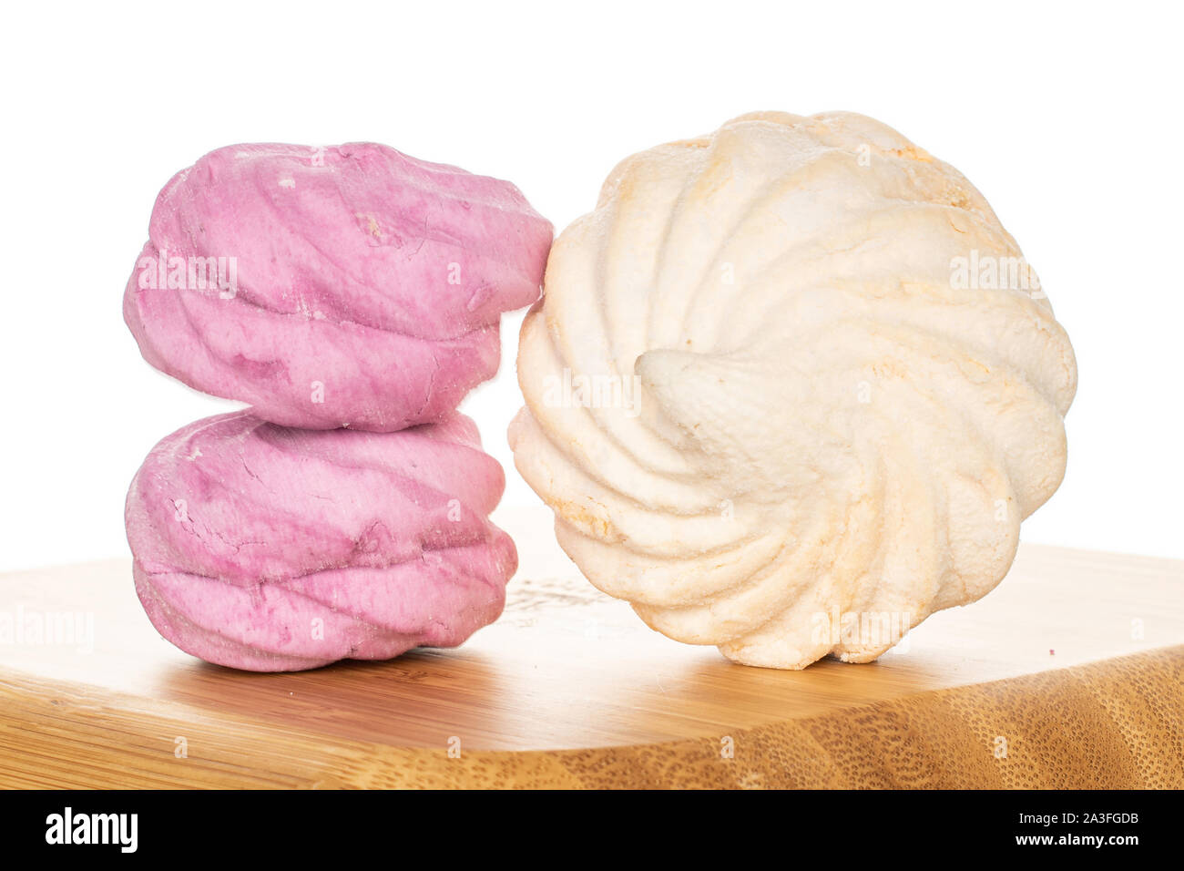Group of three whole fresh pastel zefir on wooden square plate isolated ...