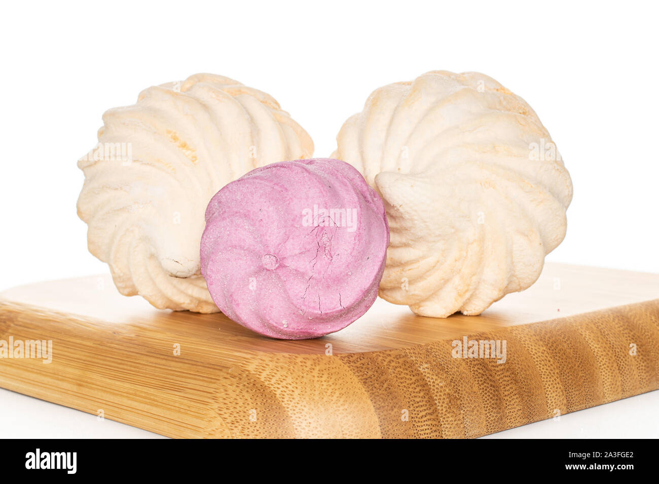 Group of three whole fresh pastel zefir on wooden square plate isolated ...