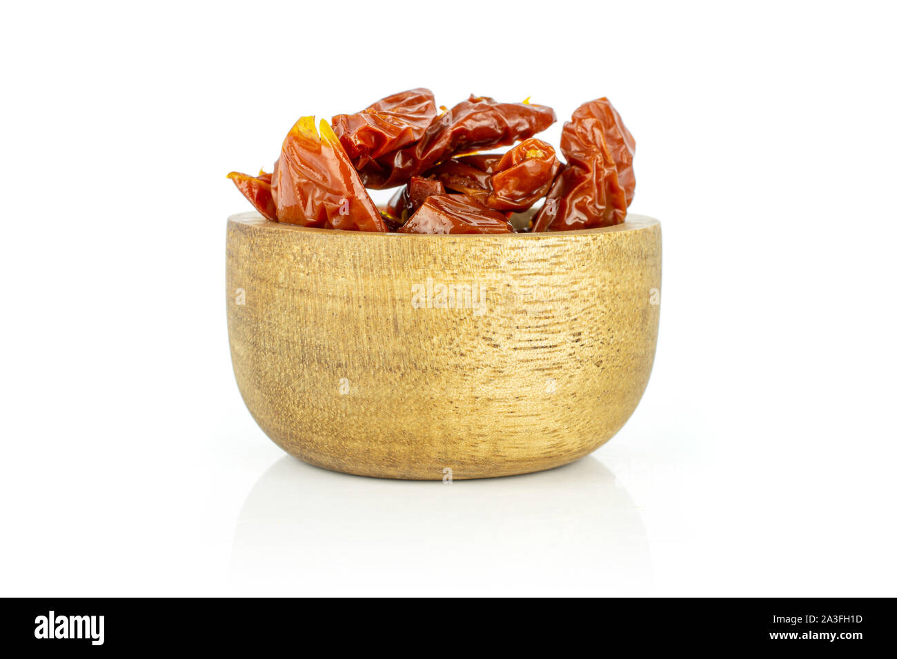 Lot of slices of cured dry red cherry tomato in wooden bowl isolated on ...