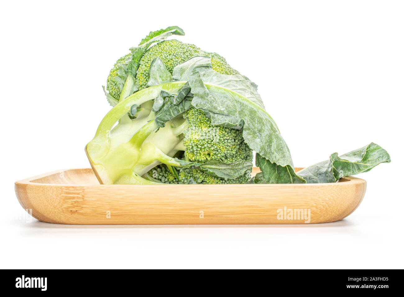 One whole fresh green broccoli on wooden square plate isolated on white ...