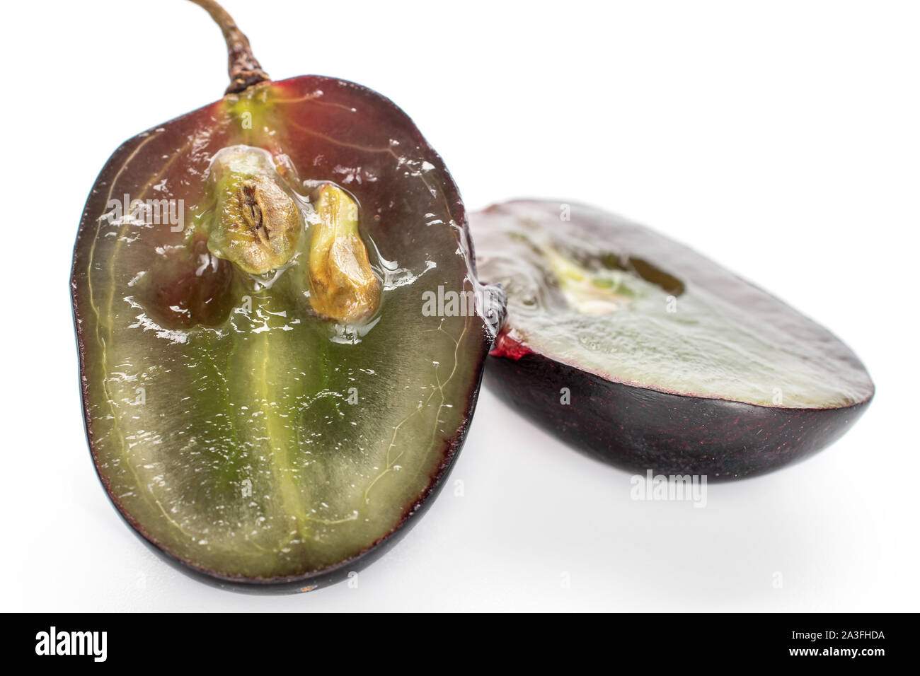 Group of two halves of fresh black grape isolated on white background ...