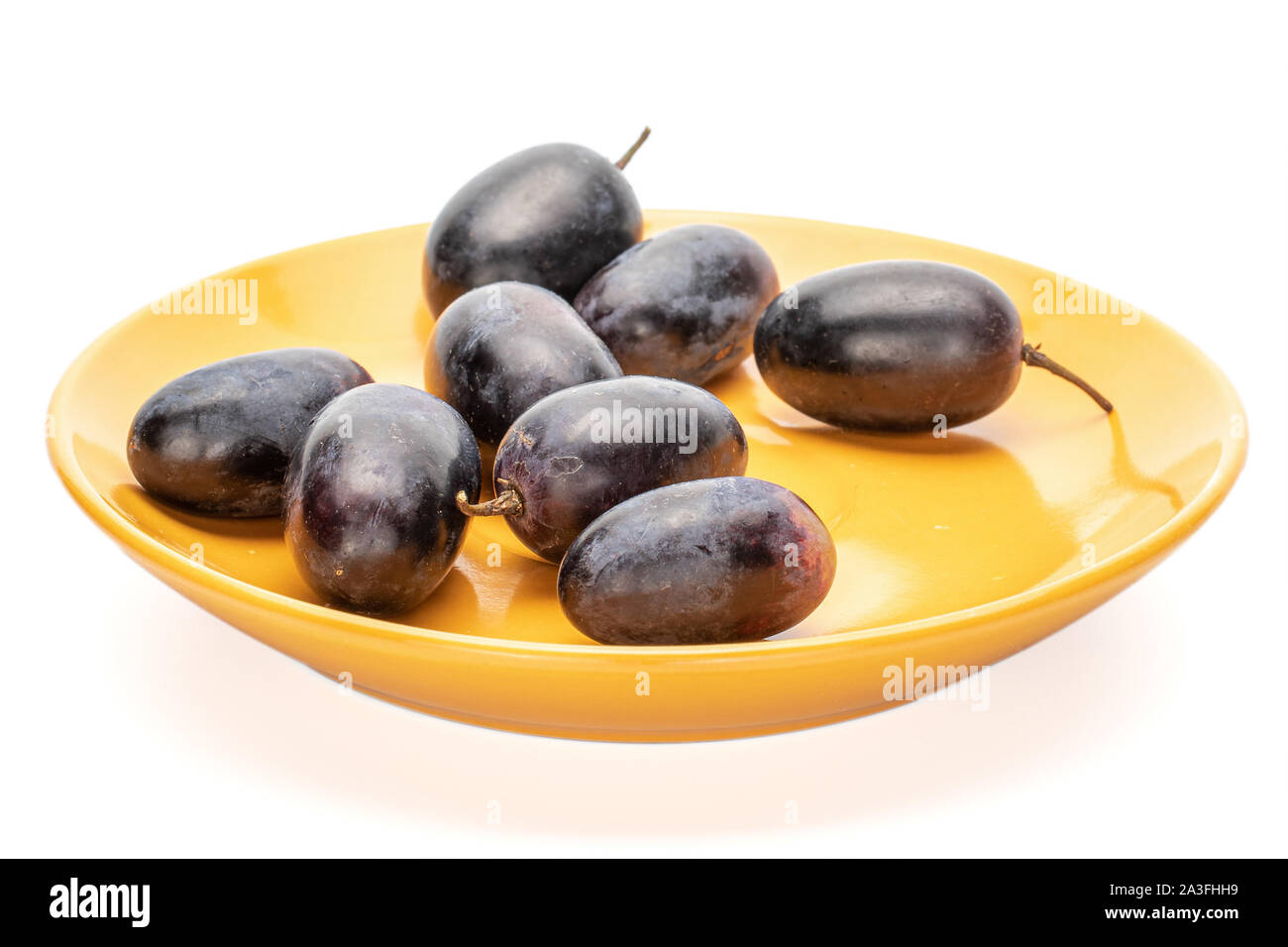 Group of eight whole fresh black grape on orange plate isolated on ...