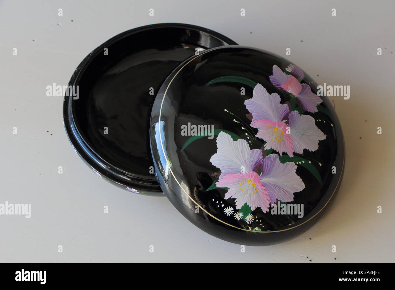 Small open black box decorated with purple flowers Stock Photo - Alamy
