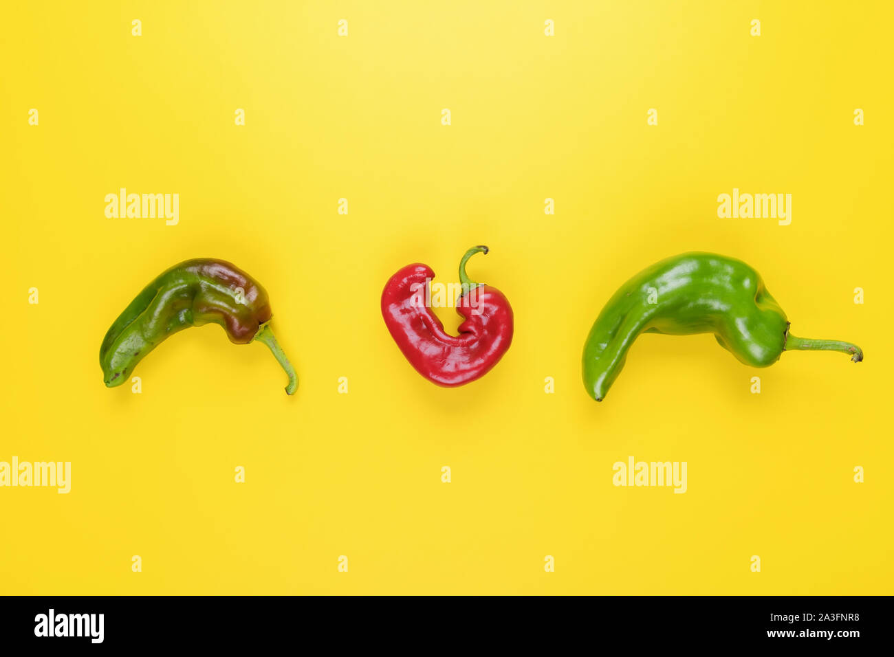 Trendy Ugly red chilli peppers on yellow background, minimal nature ...