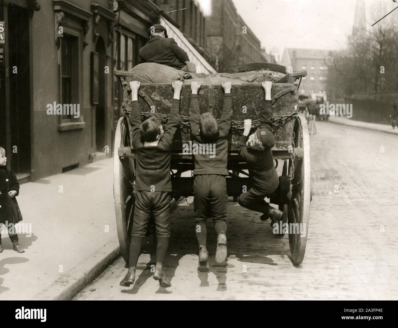 Working class children playing in London c.1920s - hanging of the back ...