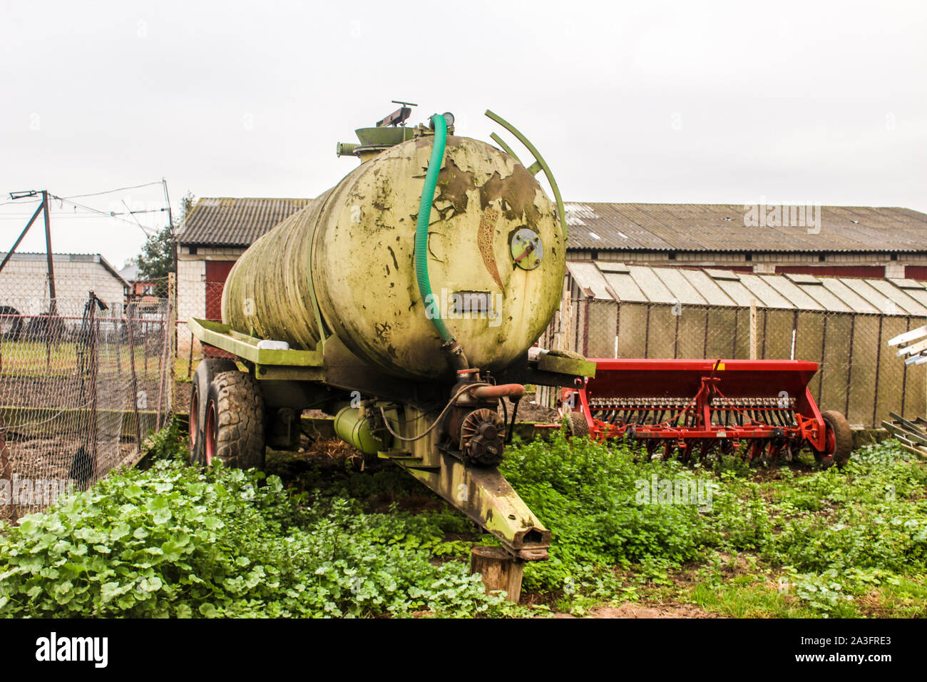 Tank for various liquids on a dairy farm. Barn and seeder in the ...