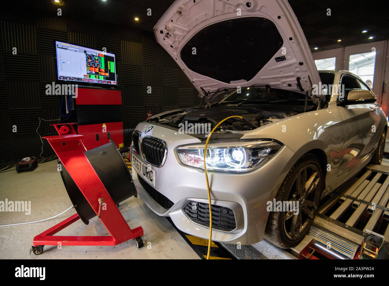 Car on a rolling road being tuned up on a dyno for performance and EDU ... Car on a rolling road being tuned up on a dyno for performance and EDU ...
