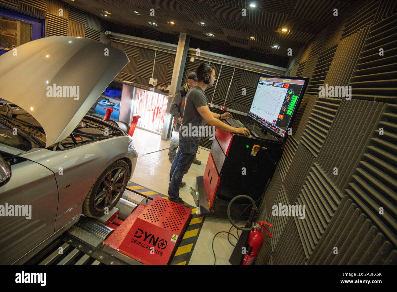 Car on a rolling road being tuned up on a dyno for performance and EDU ... Car on a rolling road being tuned up on a dyno for performance and EDU ...