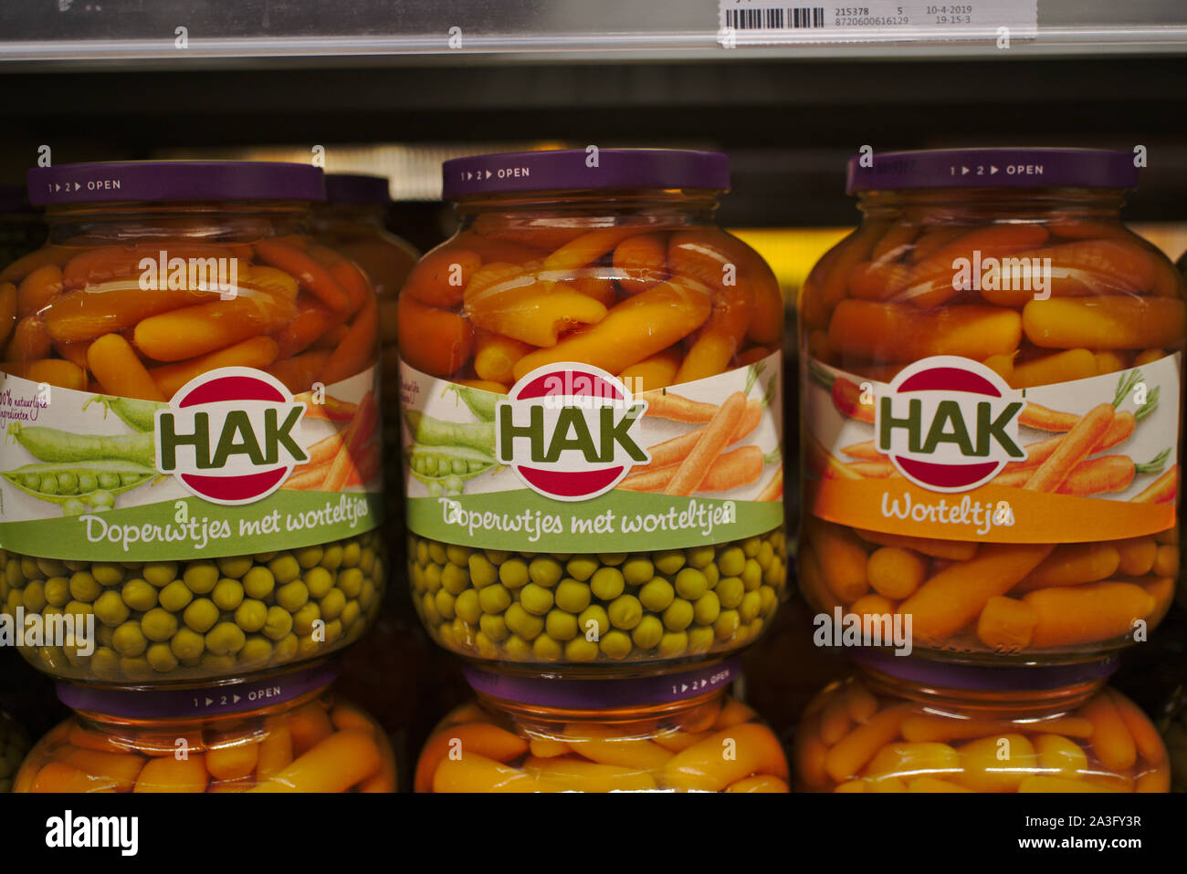 Processed carrots and peas in bottles on supermarket shelf. Germany ...