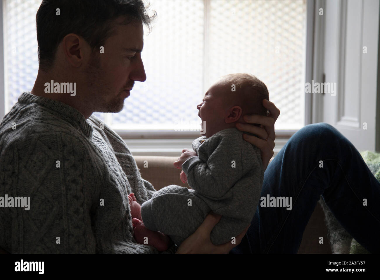 Father comforting a crying upset baby. Fatherhood, parenting concept ...