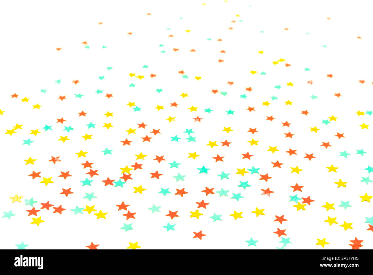 Orange and yellow decorative star shapes scattered over white surface ...