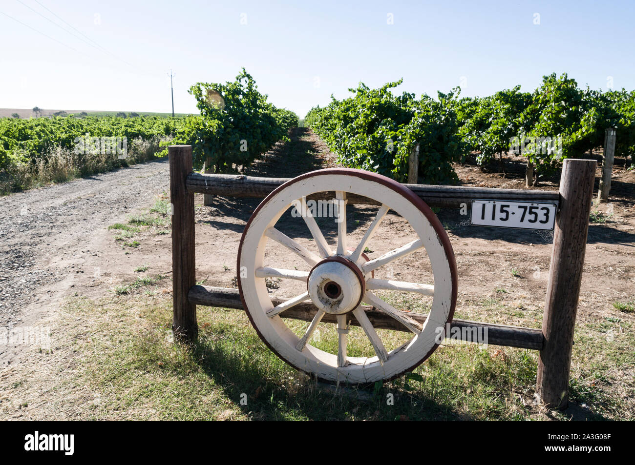 A driveway with a wagon wheel gate leading into a winery in the Barossa ...
