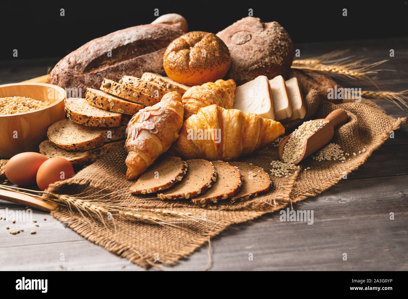 Different kinds of bread with nutrition whole grains on wooden ...