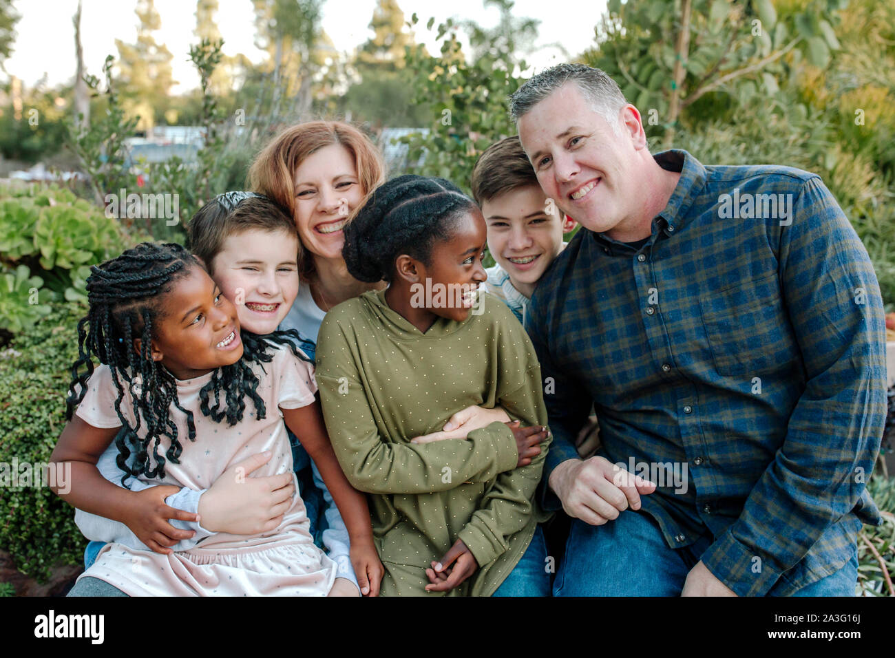 Joyful multiracial family laughing and hugging outdoors Stock Photo - Alamy