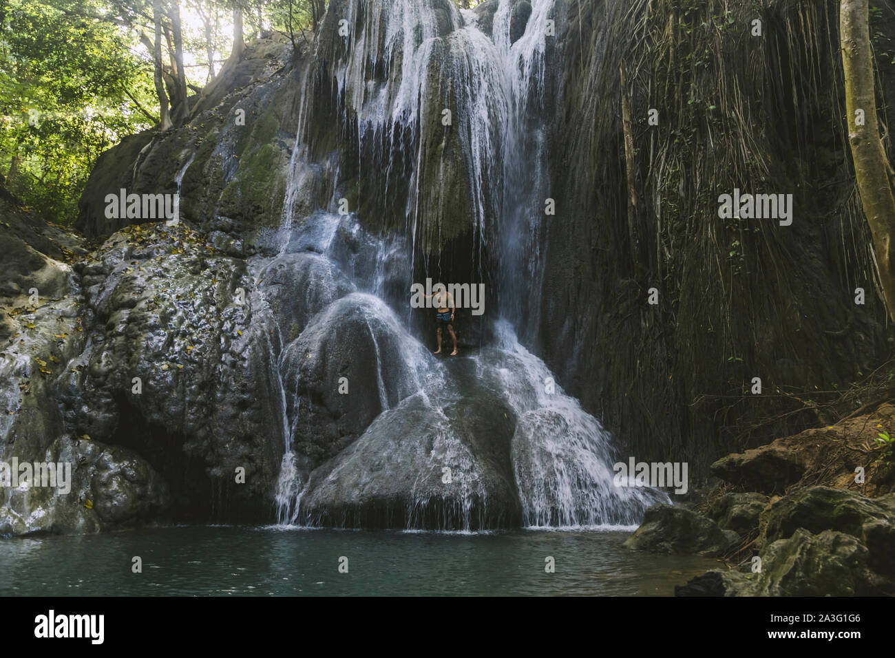 Man standing under waterfall Stock Photo - Alamy