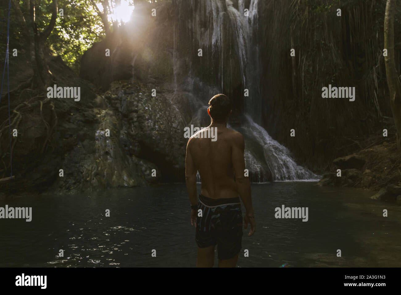 Man standing near waterfall Stock Photo - Alamy