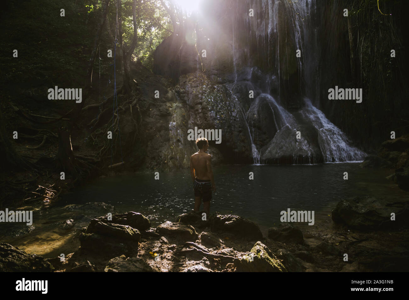 Man standing near waterfall Stock Photo - Alamy