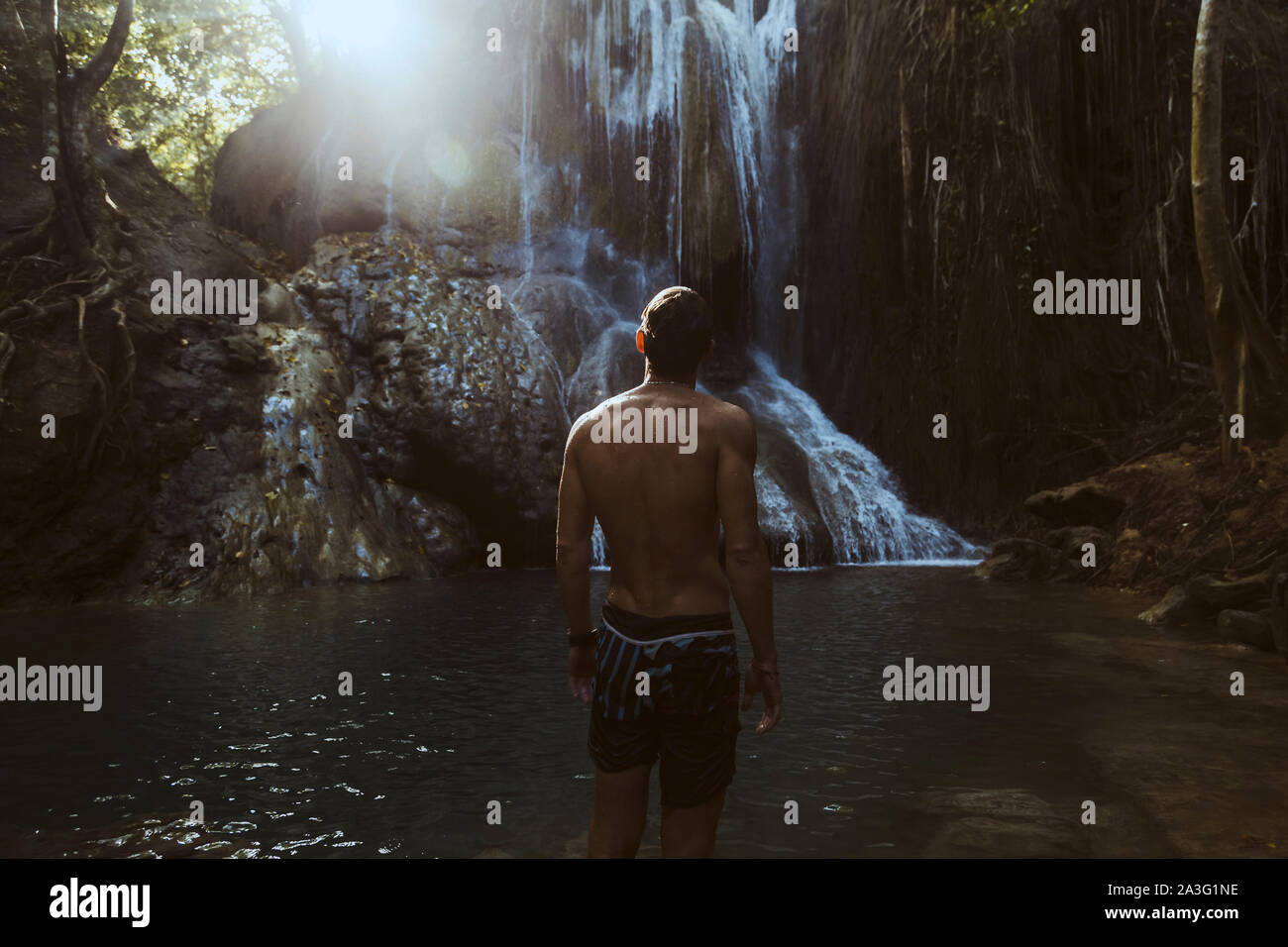 Man standing near waterfall Stock Photo - Alamy