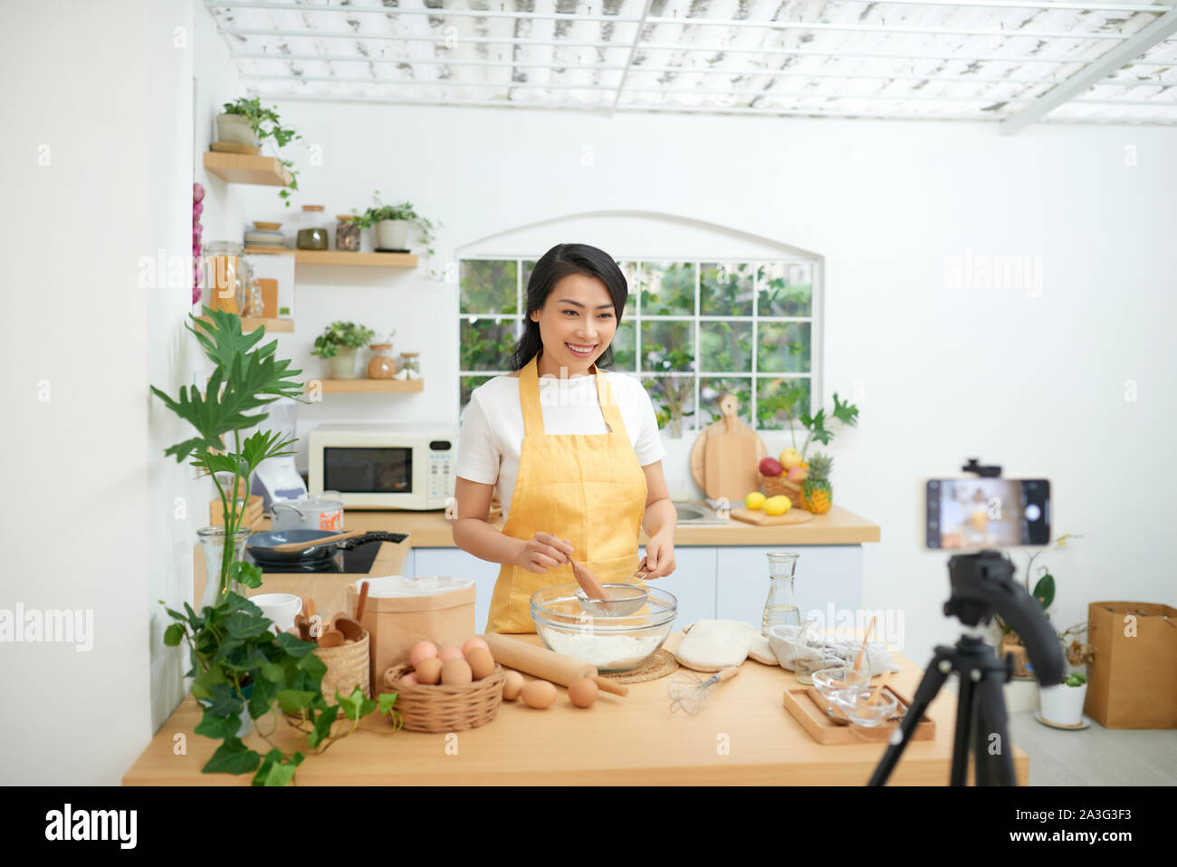 Pretty young asian female food blogger working on a new video and ...