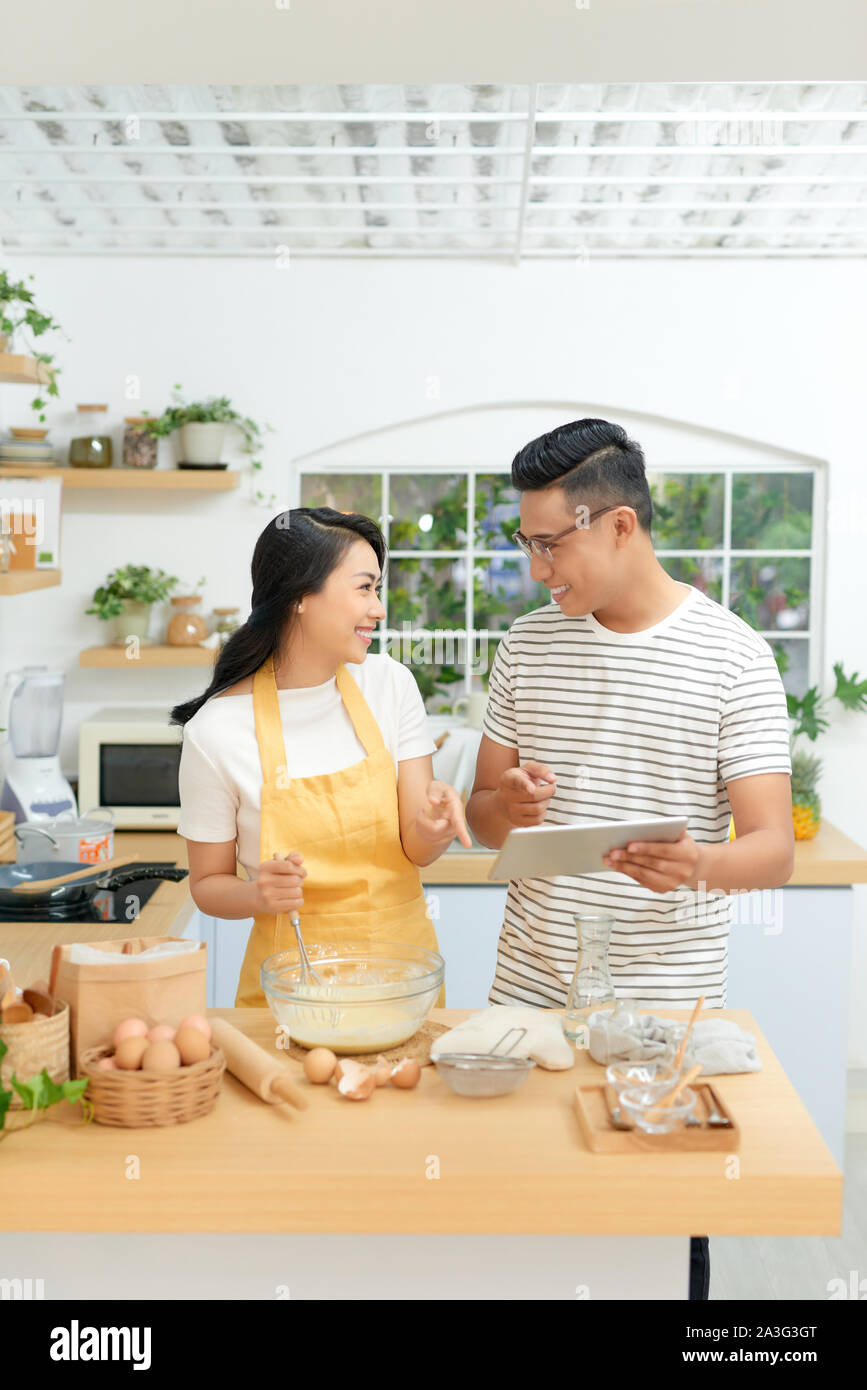 Couple in kitchen looking at recipe on internet Stock Photo - Alamy