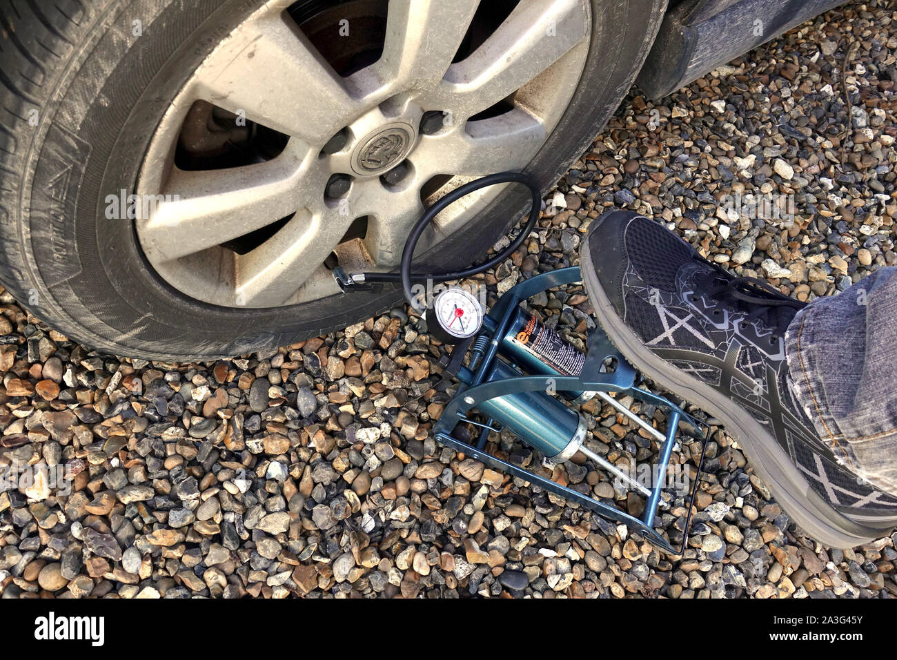 Camberley, Surrey, UK - February 25 2018: Man's foot pumping up a flat ...