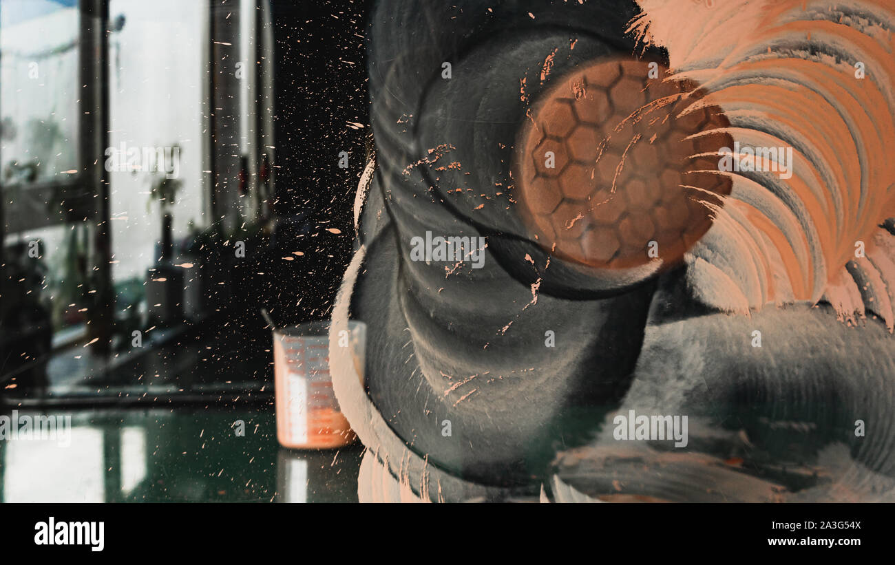 Professional glass polishing tool seen through glass, close-up on the ...