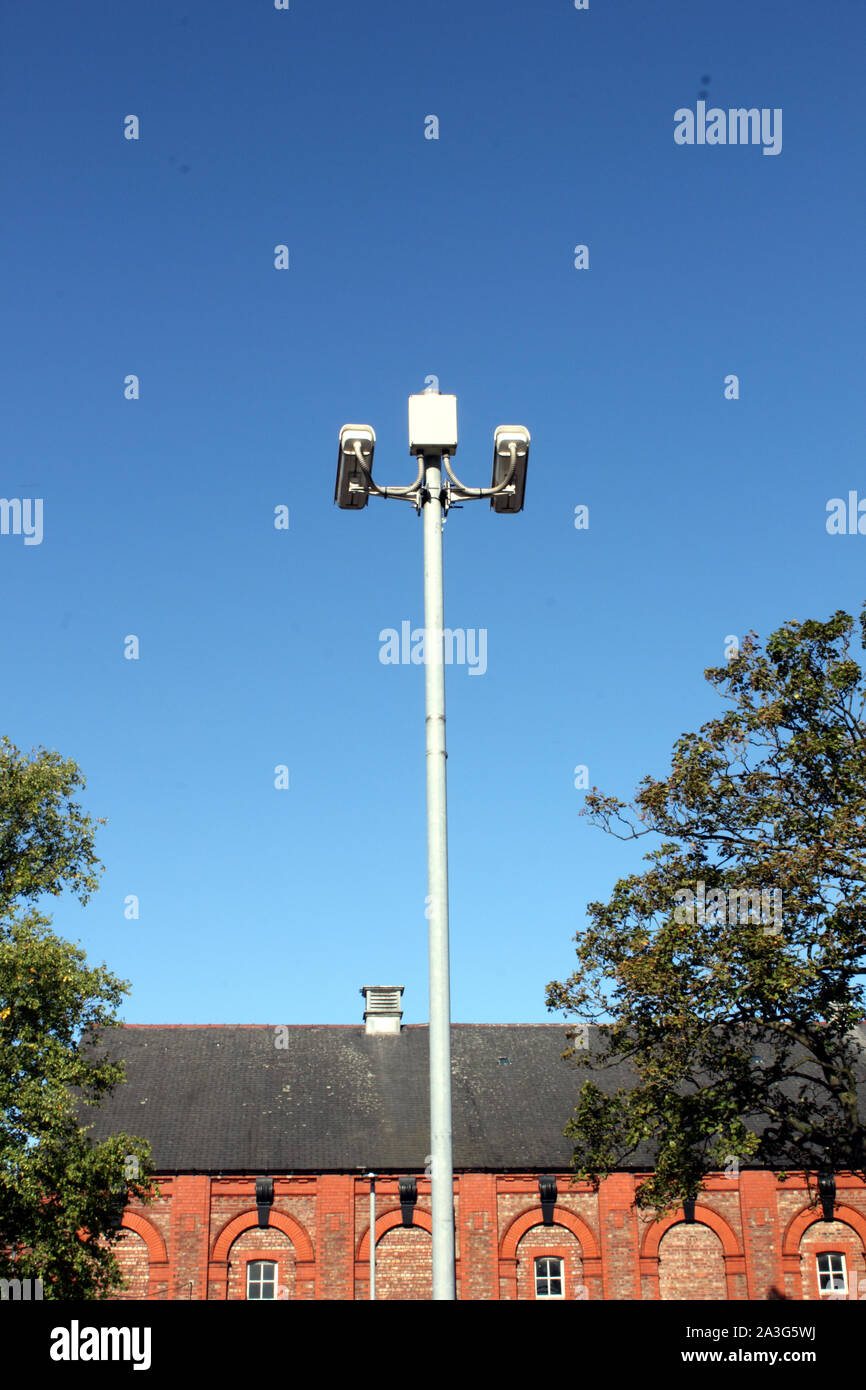 Upright view of security cameras on tall pole against deep blue sky ...