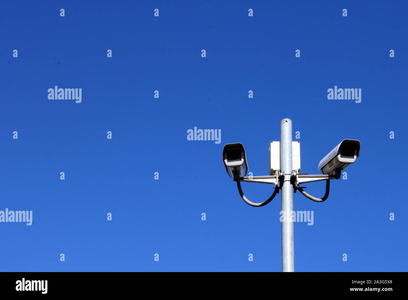 Landscape view of security cameras on tall pole against deep blue sky ...