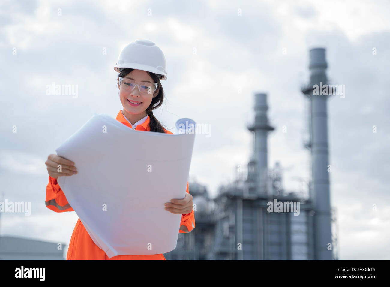 Asian female engineer with a blueprint outside the factory Stock Photo ...